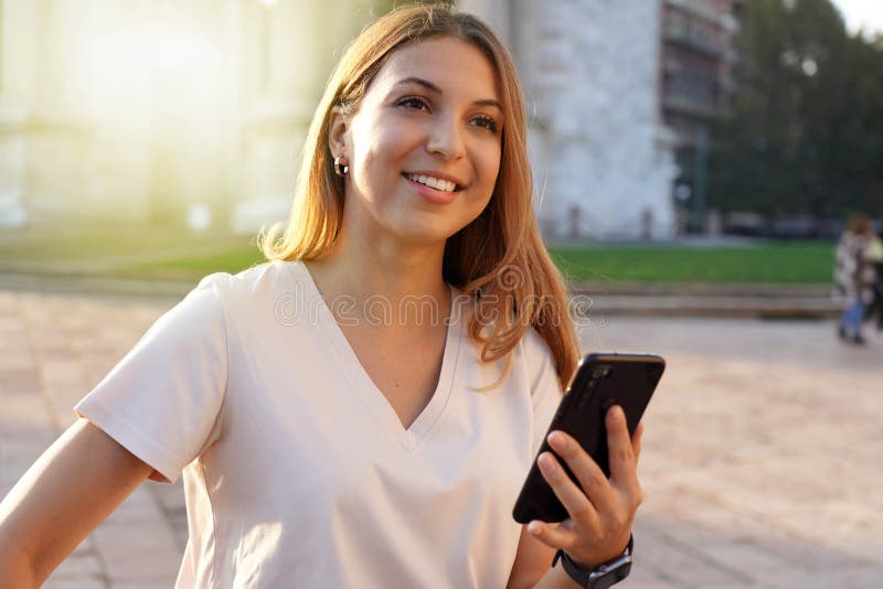 Stylish Young Woman Looking Forward Using Smartphone in City Stock ...