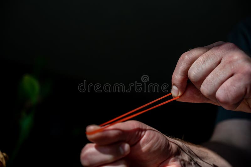 Subjective Focus on Rubber Band Pulled Taunt Being Aimed at the Camera ...
