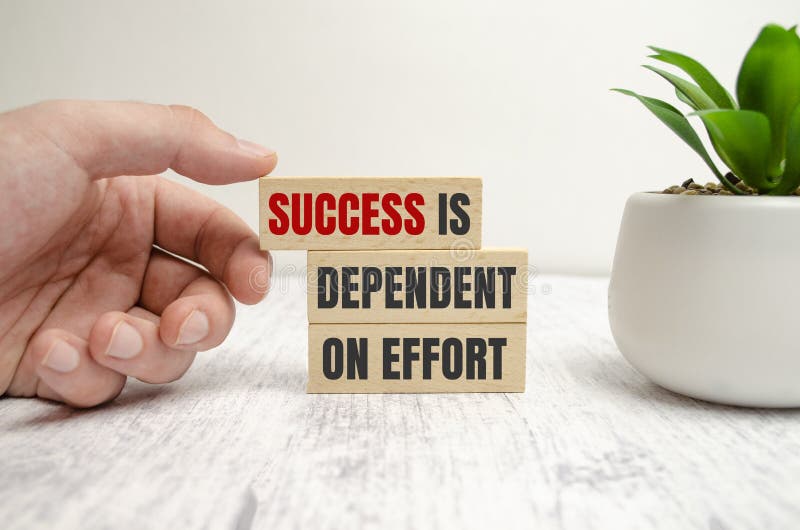Success is Dependent on Effort Sign on Wooden Blocks with Man Hand ...