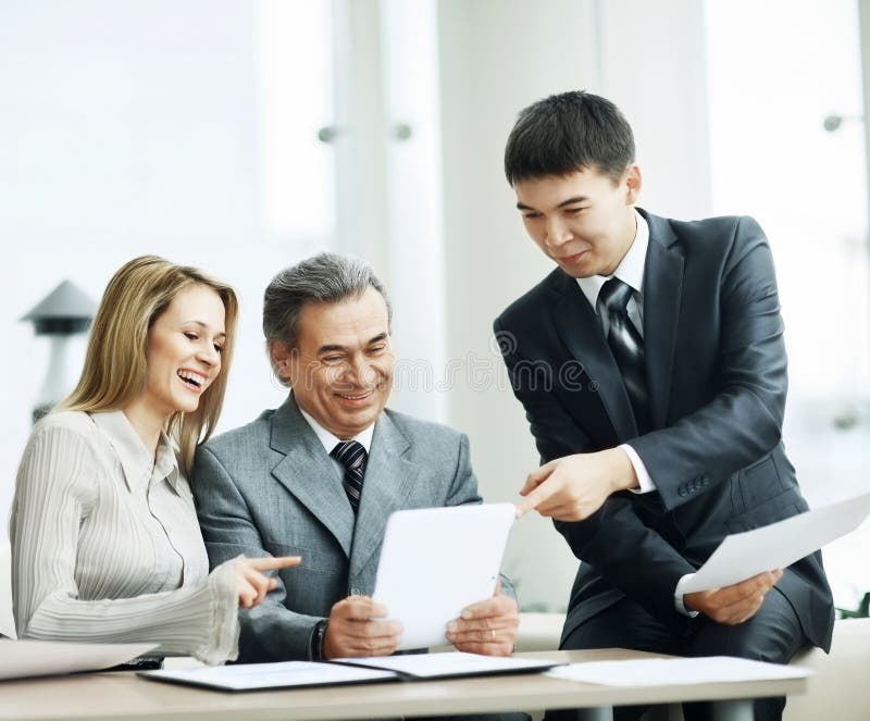 A Successful Business Group Discusses a Work Plan Using a Tablet Stock ...