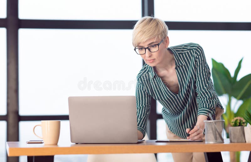 Successful Business Lady Using Laptop Taking Notes Standing in Office ...