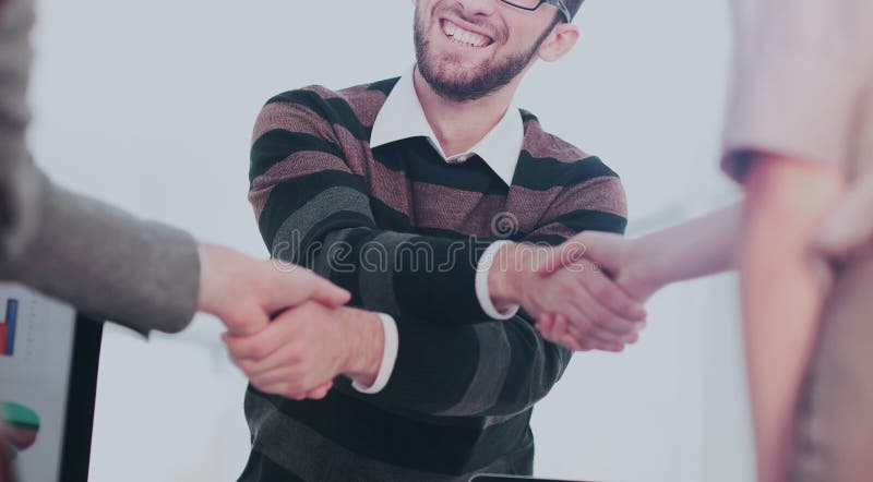 A Black Woman Gives a Double Handed Handshake To a Client Sitting in ...