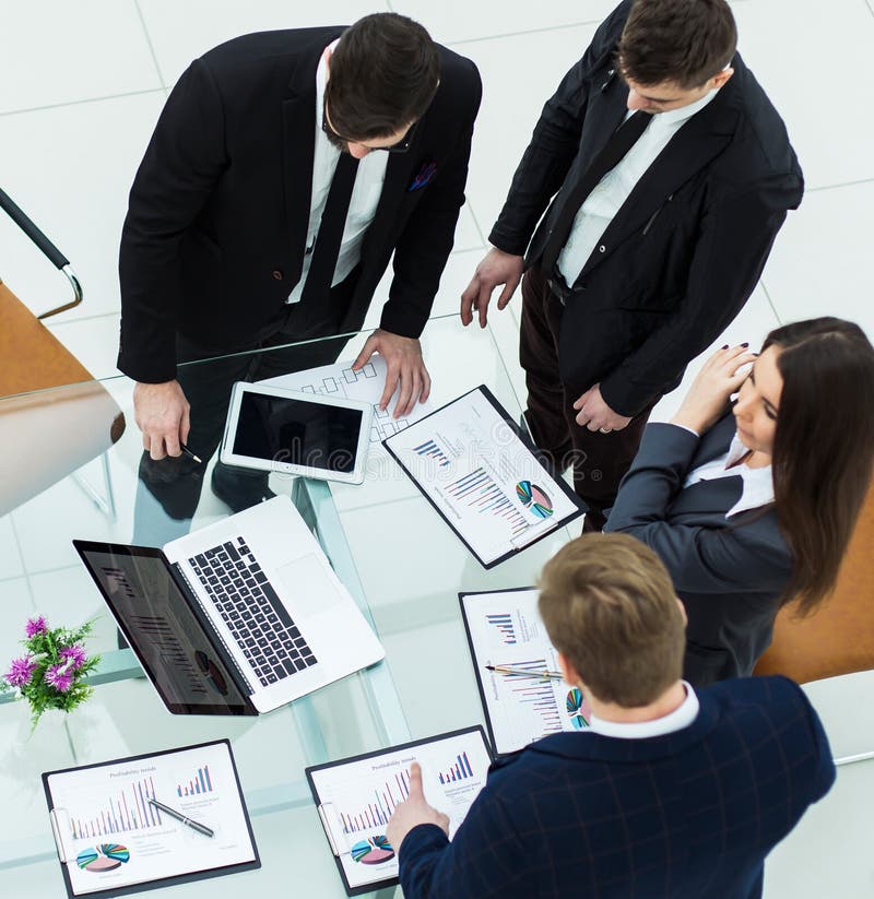 Successful Business Team Discussing Marketing Graphics before the ... Successful Business Team Discussing Marketing Graphics before the ...