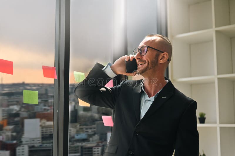 Successful Businessman Talking on Mobile Phone while Standing Near ... Successful Businessman Talking on Mobile Phone while Standing Near ...