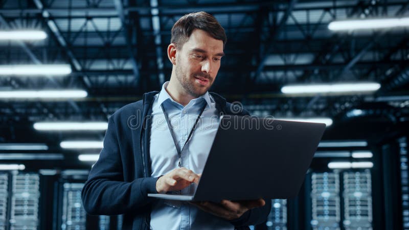 Successful Data Center it Specialist Using Laptop Computer. Server Farm ...