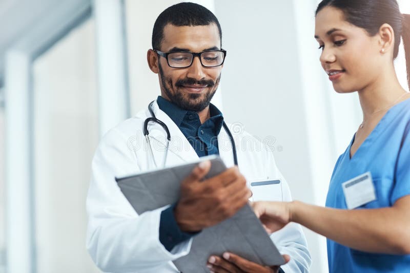 Teamwork Makes the Hospital Work. Two Young Doctors Using a Digital ...