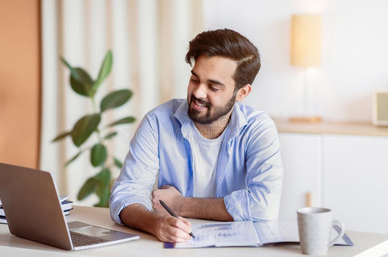 Successful Eastern Entrepreneur Working with Documents and Laptop at Home Office Stock Photo ...