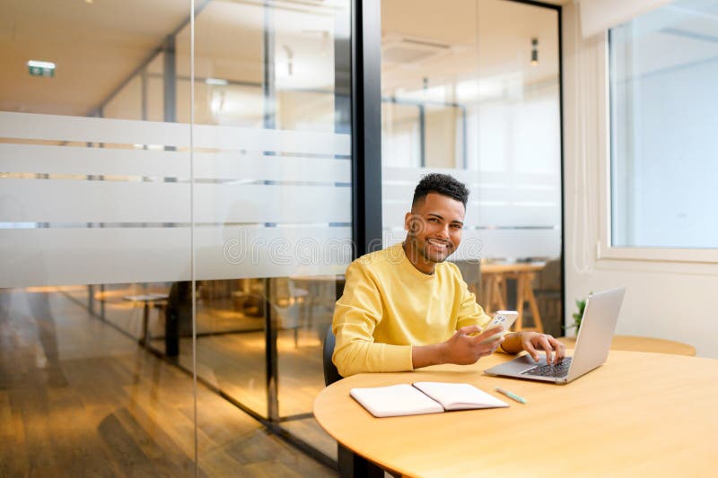 Successful Indian Male Employee Using Laptop and Smartphone for Work at ...