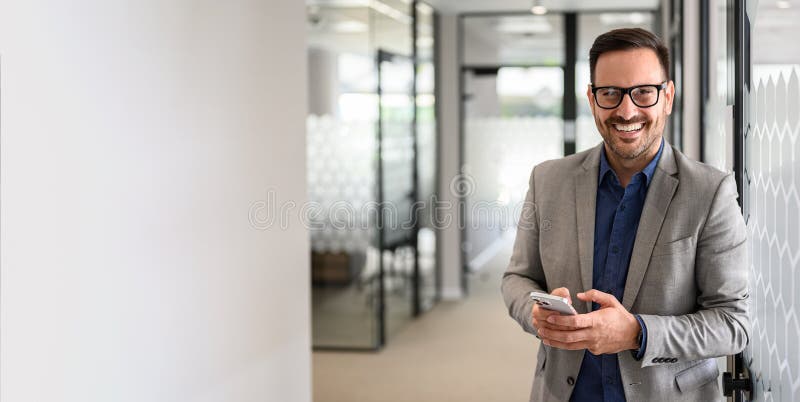 Successful Male CEO Messaging Over Cellphone and Looking at Camera ...