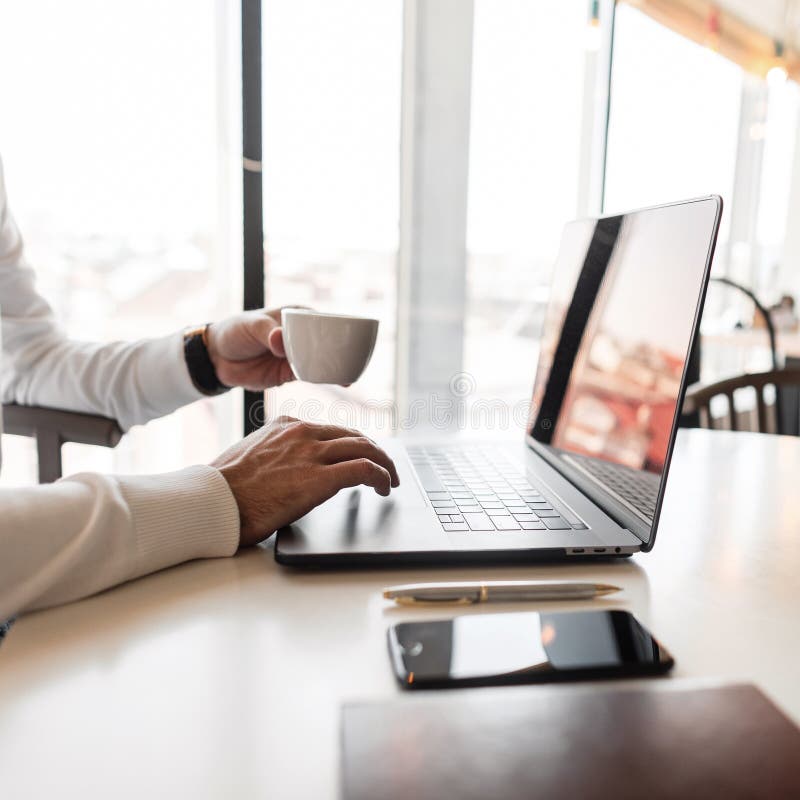Successful Man Working on a Laptop and Drinking Coffee while Sitting in ...
