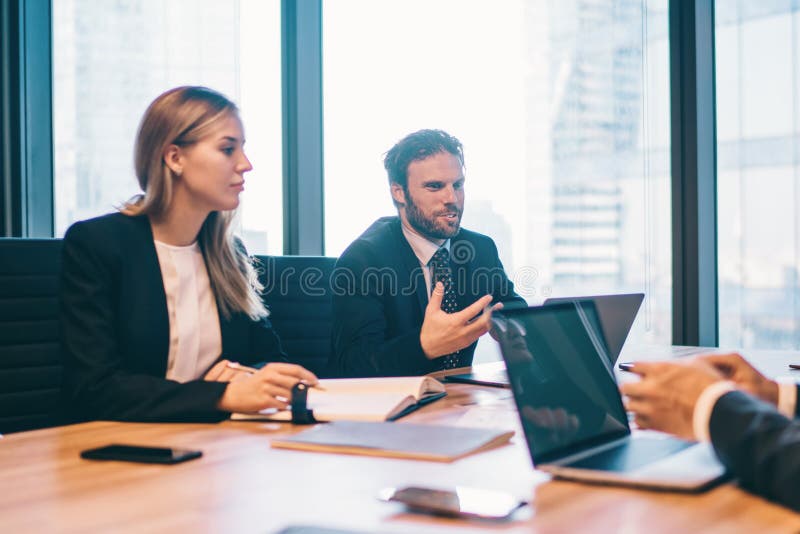 Successful Office Employees Discussing Ideas while Sitting at Table ...