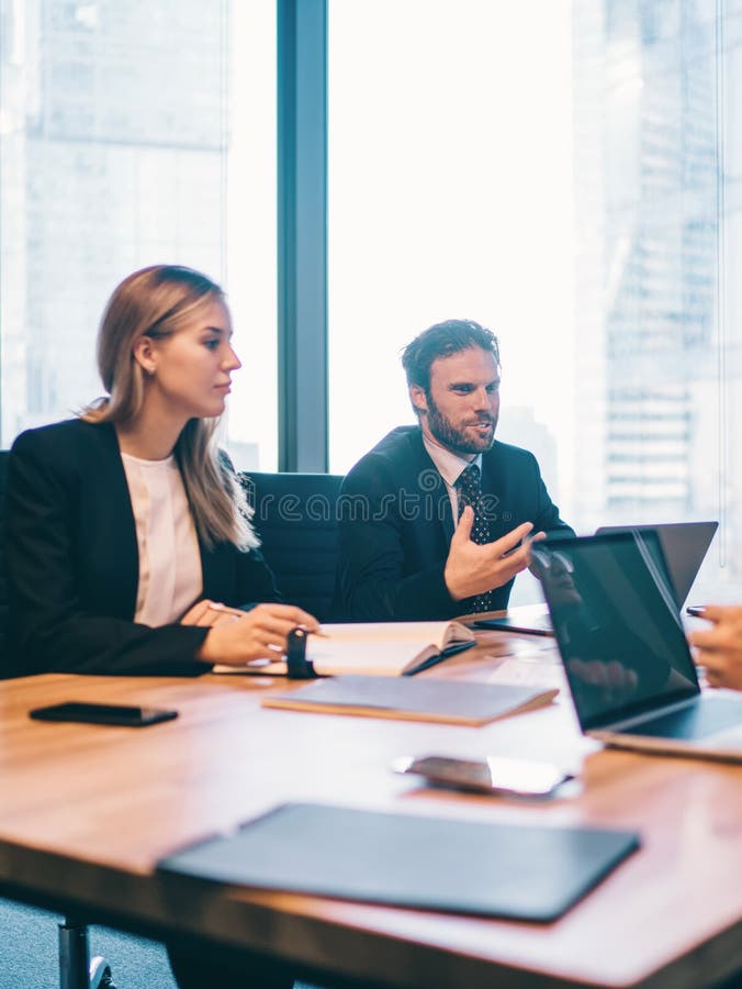 Successful Office Employees Discussing Ideas while Sitting at Table ...