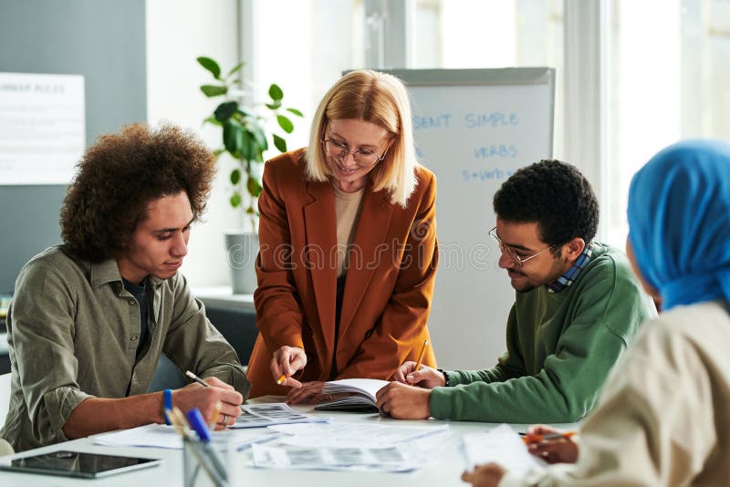 Successful Teacher Consulting One of Students at Lesson Stock Photo ...