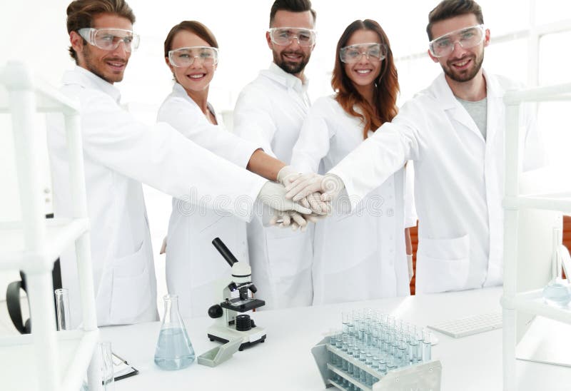 Successful Team of Young Scientists with Hands Clasped Together. Stock ...