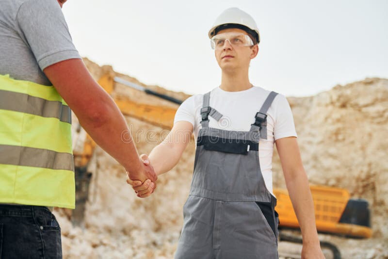 Successful Teamwork. Two People is on the Borrow Pit at Daytime ...
