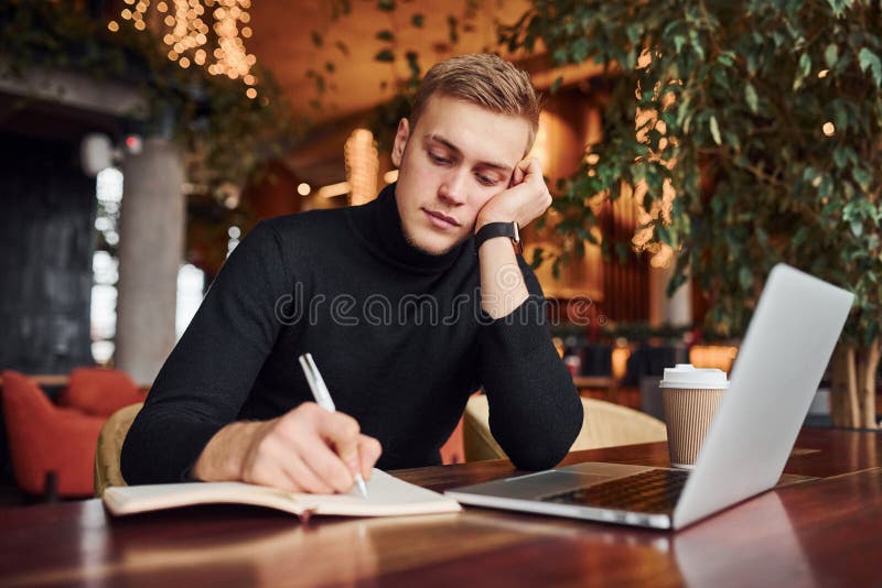 Successful Young Guy Sits in Cafe by Table with His Laptop on it Stock ...