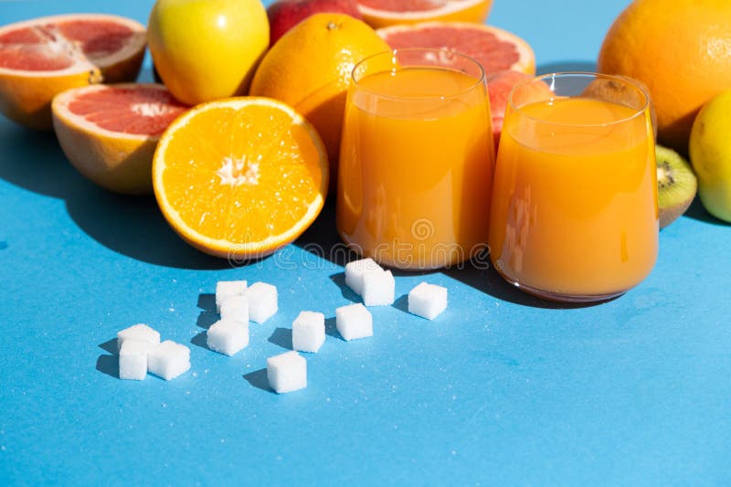 Sugar Content in Fruit Juices. Sugar Cubes and Glasses of Multifruit ...