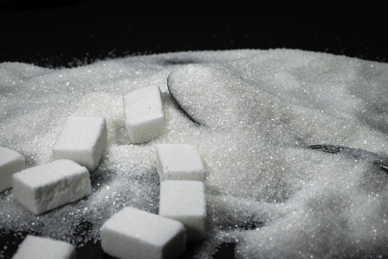 Sugar Cubes and Grain Sugar in a Spoon, Pile on Black Background Stock ...