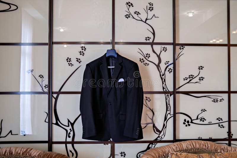 A Suit Hanging on a Wall in a Room Stock Image - Image of suit, tree ...