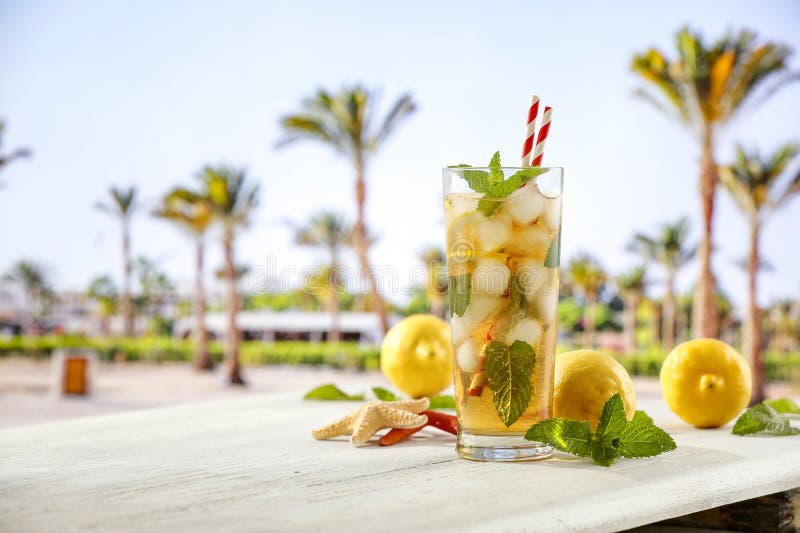 Large Glass of Lemonade with Ice and Citrus Fruit on a Wooden Table ...