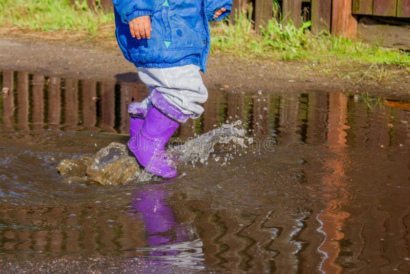 Summer Stroll Kid in Rubber Boots in a Puddle. Stock Photo - Image of ...