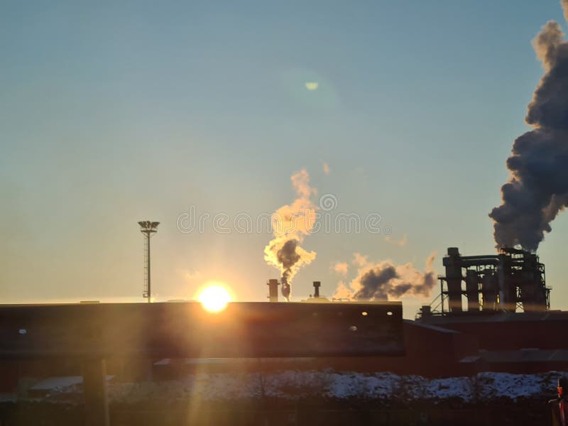 Sun Behind Factory Area stock image. Image of setting - 208321447
