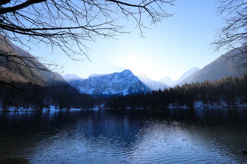 Sun Behind the Mountains and the Reflection the Mountains on Alpine ...