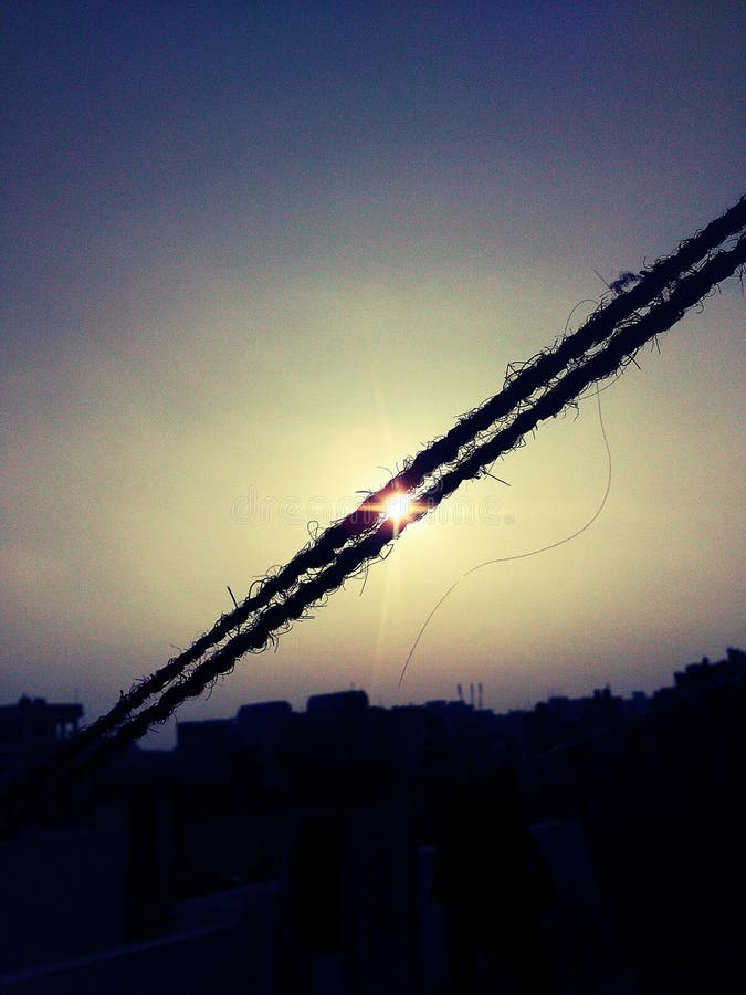 Sun caught between ropes. stock image. Image of caught - 85055737