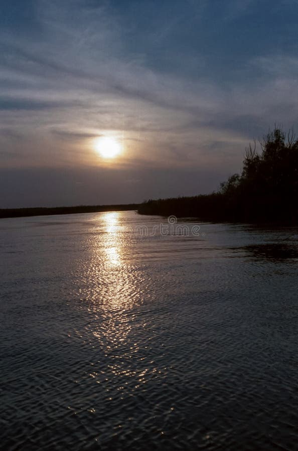 Sun in the Clouds and Reflection in the Water Early in the Morning Over ...