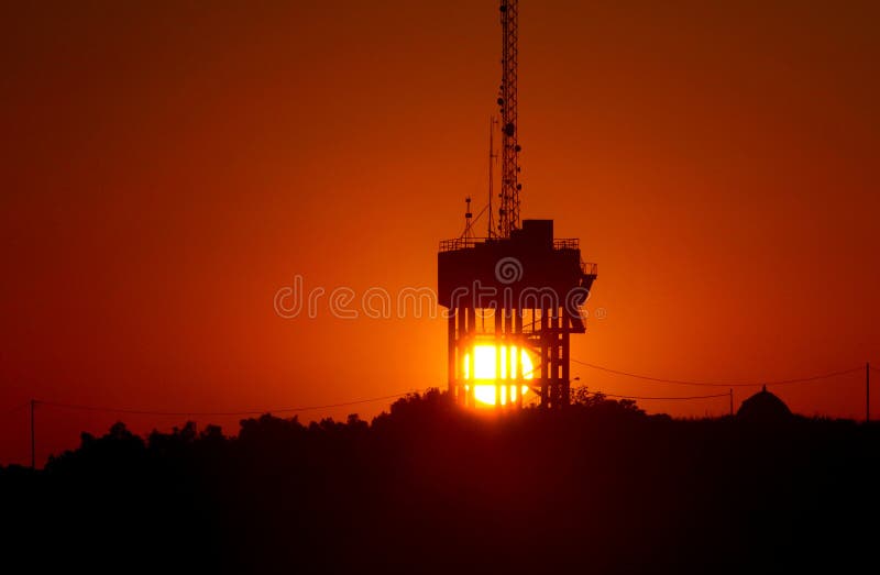 Sun disk behind water tank stock photo. Image of sunset - 303573206