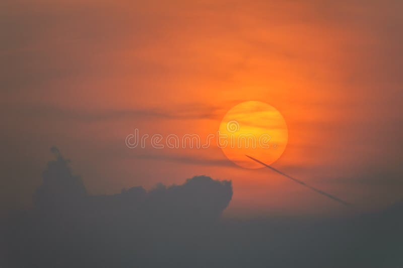 Sun Disk through the Clouds at Sunset Above the Horizon. Stock Image ...