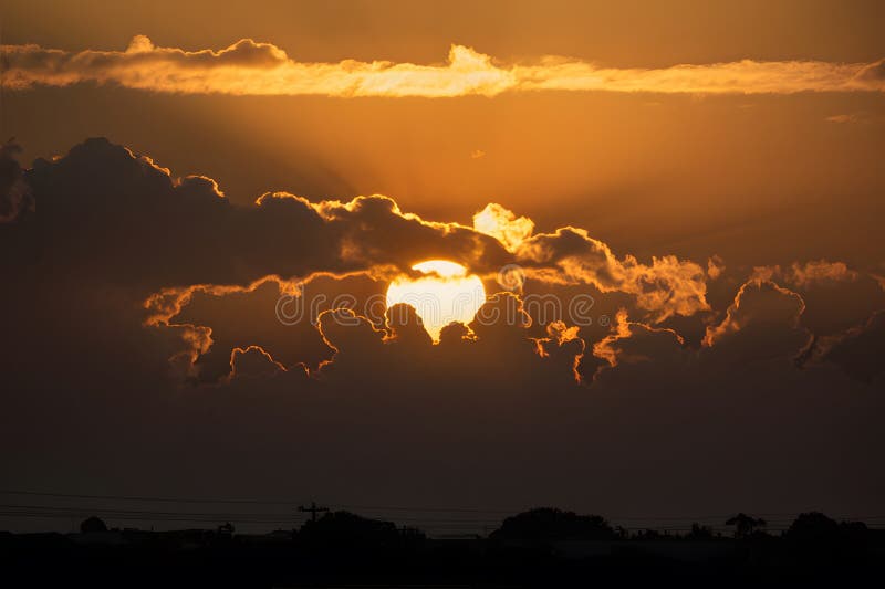 Sun Disk Peeks Out from Behind Dramatic Backlit Clouds Stock ...