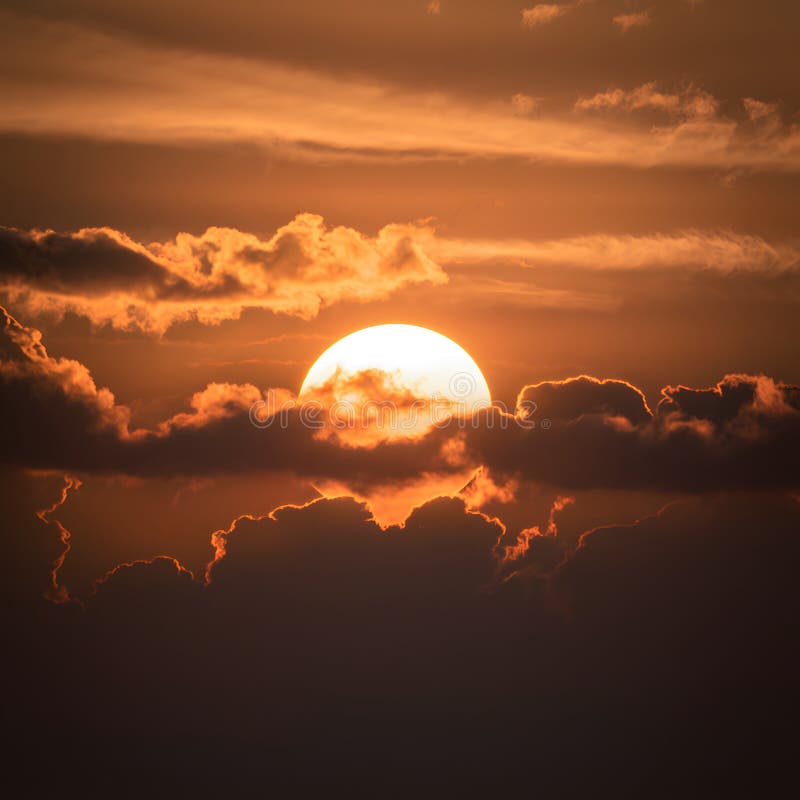 Sun Disk Peeks Out from Behind Dramatic Backlit Clouds Stock ...