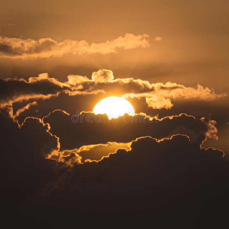 Sun Disk Peeks Out from Behind Dramatic Backlit Clouds Stock ...