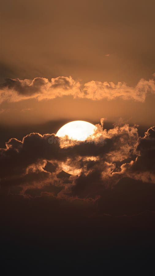 Sun Disk Peeks Out from Behind Dramatic Backlit Clouds Stock ...