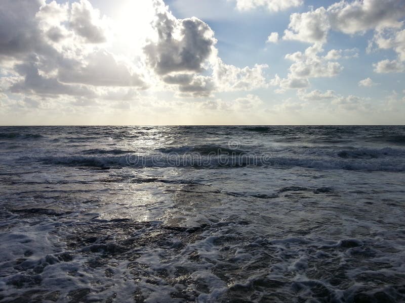 Sun hiding above sea stock image. Image of hiding, clouds - 45362145