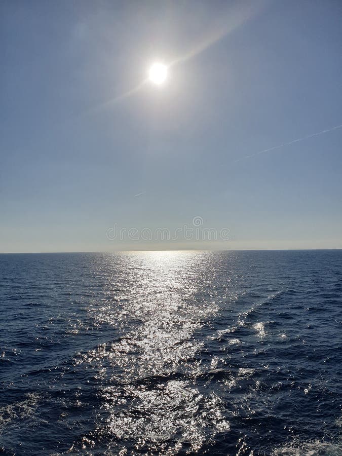 Sun high over ocean water stock image. Image of bright - 161089527