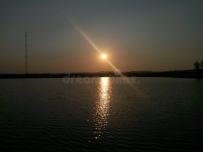 Sun with Light Effect Over Lake and Radio Transmitter on Background ...