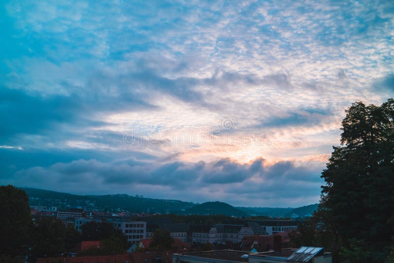Sun Lighting Up the Cloudy Sky Over the City Landscape Stock Image ...