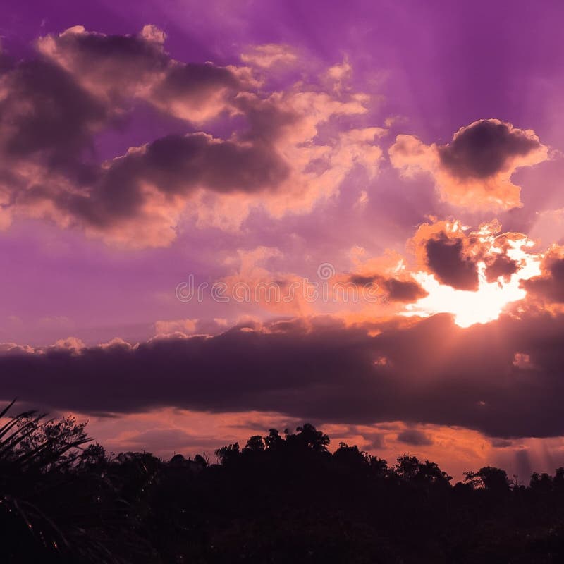 Sun Peeking Sunset stock photo. Image of clouds, purple - 179472880