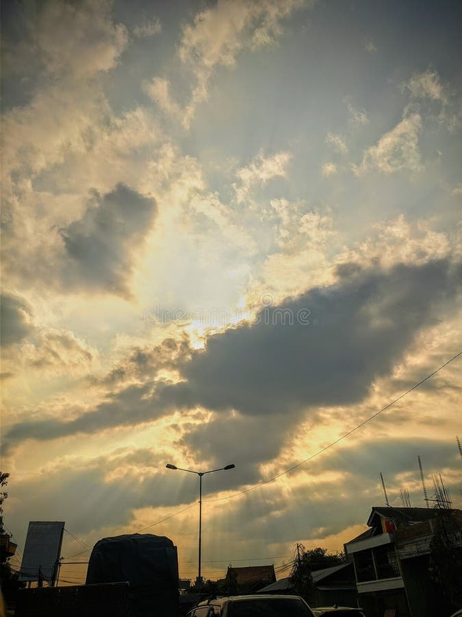 The Sun Peeks Out Over the City from Behind the Clouds Stock Image - Image of peeks, clouds ...