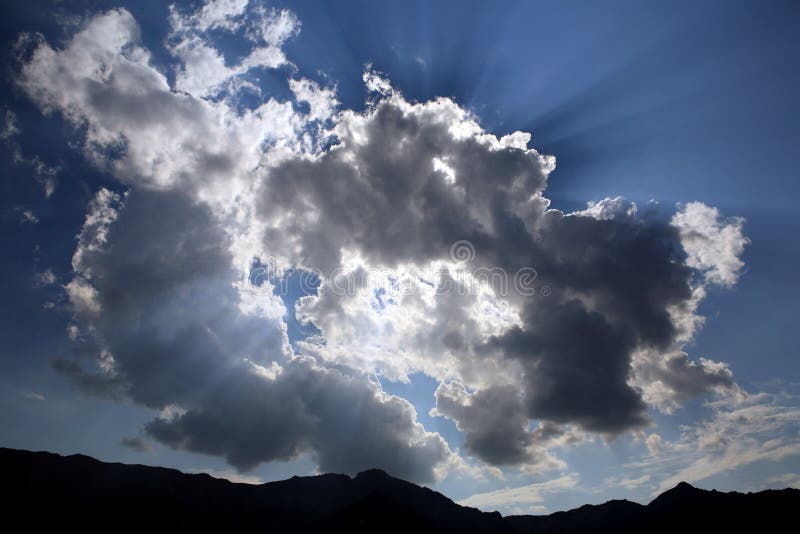 Sun Rays Behind Clouds Above Mountains Stock Image - Image of moody ...