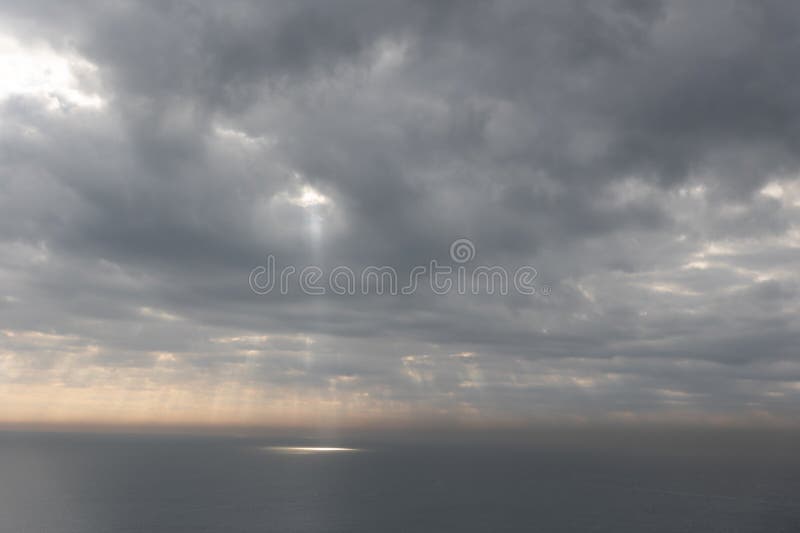 The Sun Rays Breaking through Gray Clouds Reflecting on the Sea Surface ...