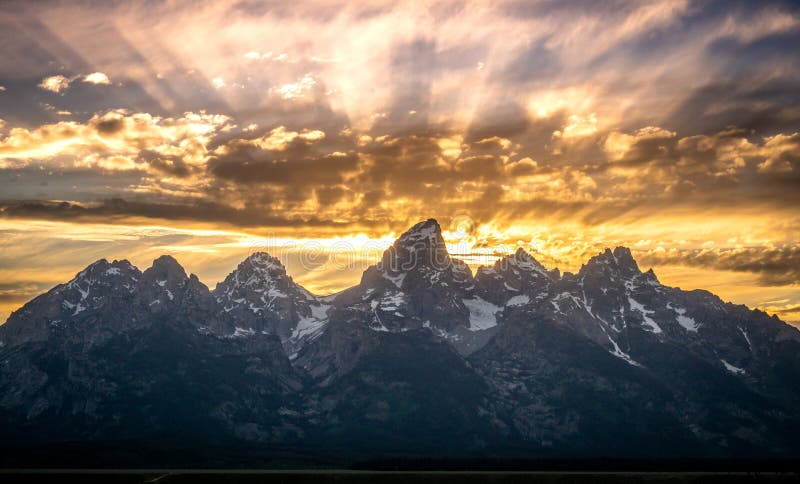 Sun Rays Burst through Evening Clouds Behind the Grand Teton Range Stock Image - Image of purple ...