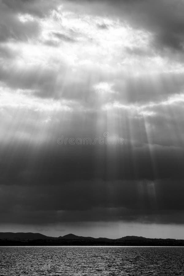 Sun Rays Coming Out through Clouds Above a Lake Stock Image - Image of ...