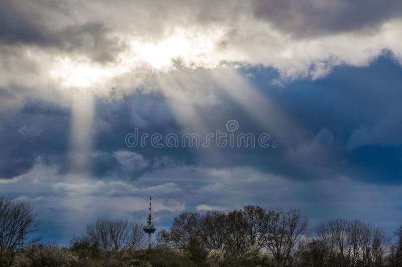 Sun Rays in the Dark Blue Sky Over the Trees and the TV Tower Stock ...