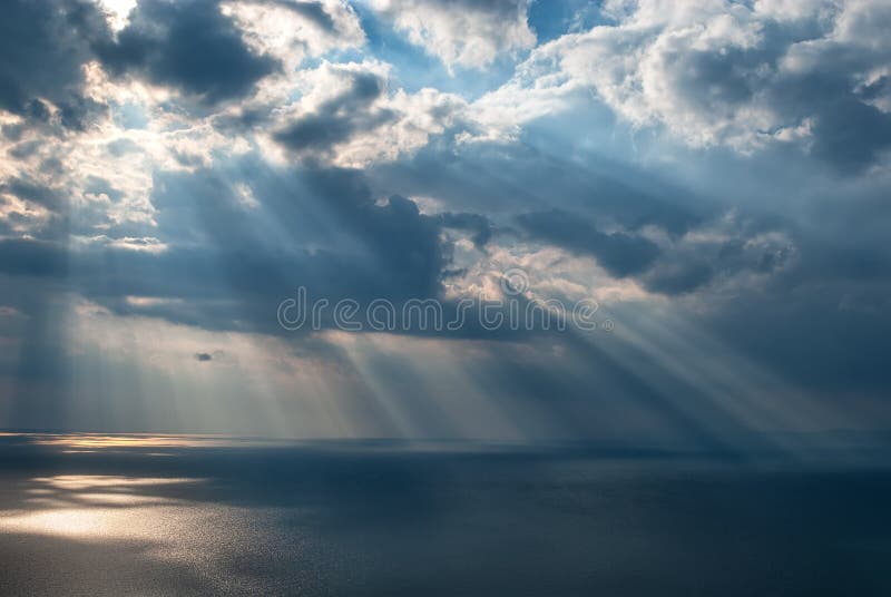 Sun Rays through Dark Clouds Over the Sea Stock Image - Image of ...