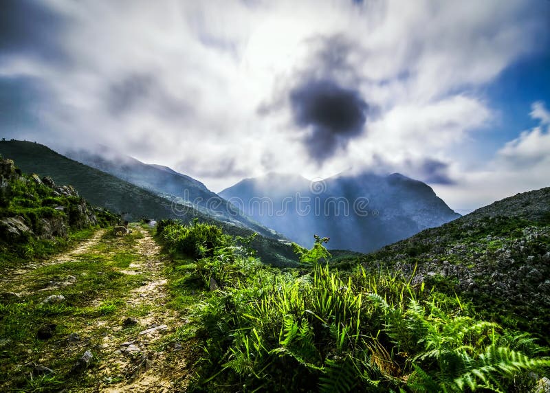 Sun Rays Filtering through Clouds Illuminating Green Mountain Path ...