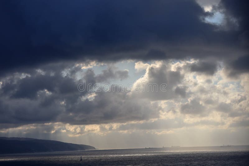 The Sun Rays Shine through the Clouds on the Sea Surface Stock Image ...