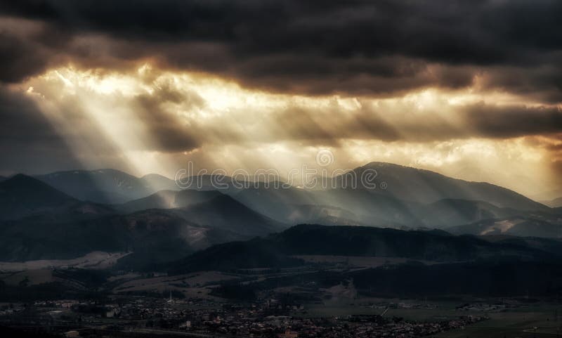 Sun Rays Shining through Dark Clouds on the Hills Stock Image - Image ...